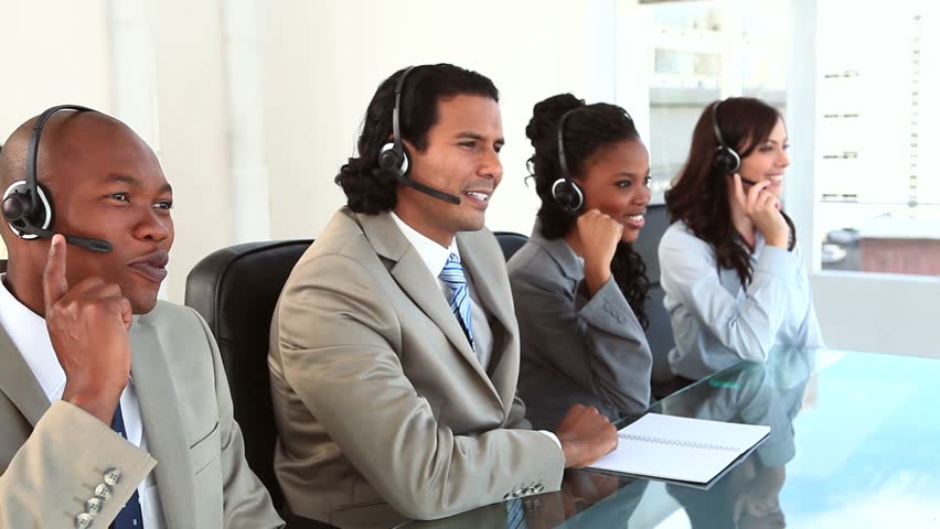 Serious Call Centre Agents Talking With Headsets In A Bright Office ... Serious Call Centre Agents Talking With Headsets In A Bright Office ...