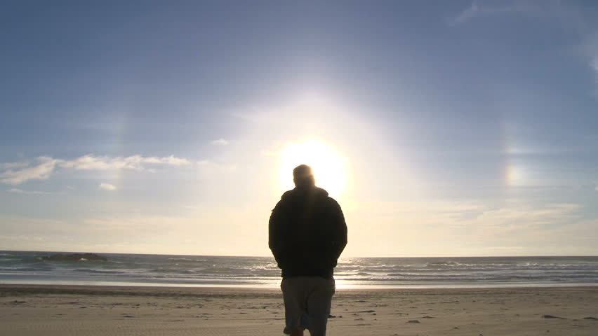 Man Walking Away On Sandy Beach To The Pacific Ocean In Oregons